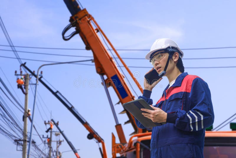 Engineer Holding Tablet and Talking on Smartphone while Controlling His ...