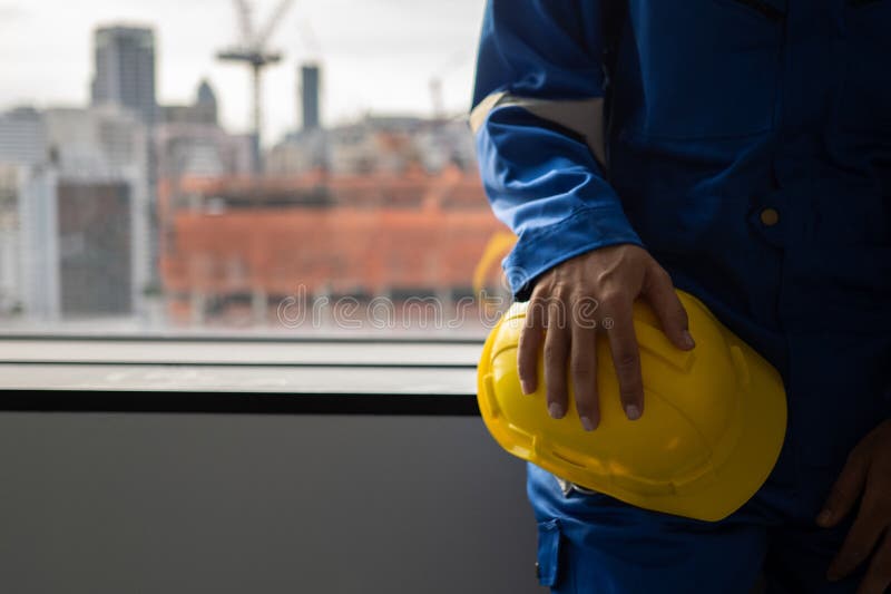 Engineer Holding Yellow Helmet with Construction Building Site ...