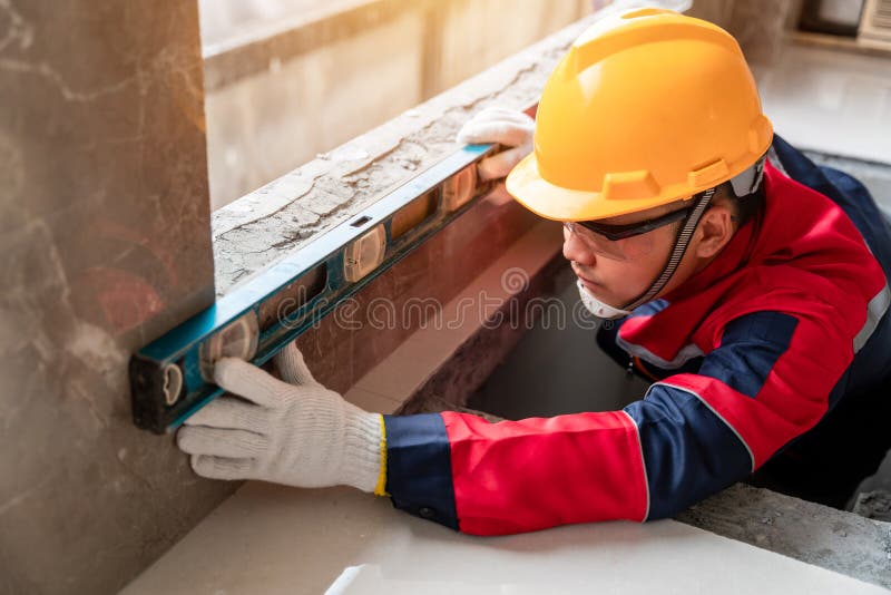 An Engineer or Inspector Wearing Safety Gear is Using the Water Level ...