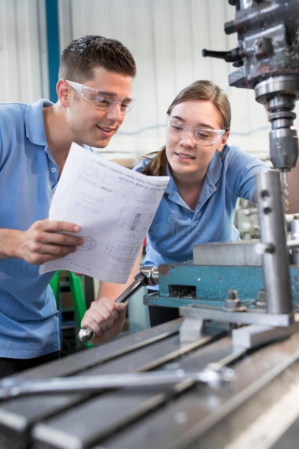 Engineer Instructing Female Apprentice on Use of CNC Machine Stock ...
