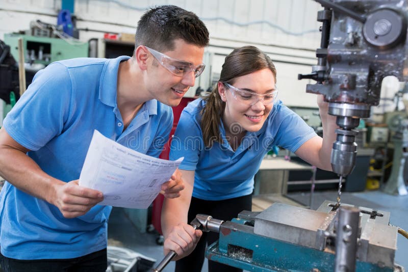 Engineer Instructing Female Apprentice on Use of CNC Machine Stock ...
