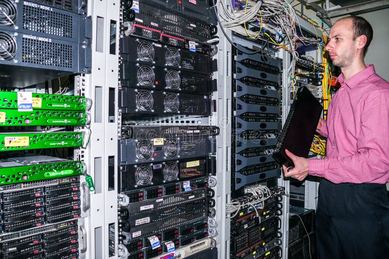 An Engineer with an Internet Switch is Near the Racks with Computer ...