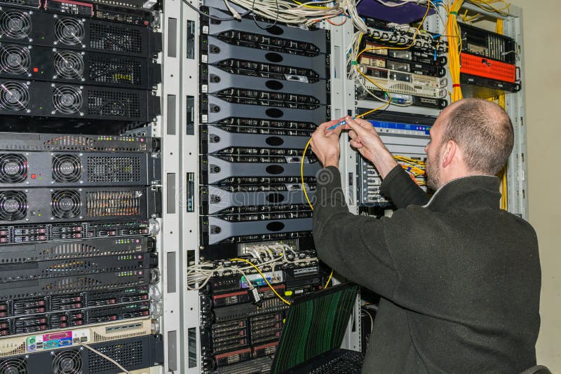 A Technician Connects a Fiber Optic Internet Cable in a Server Room. a ...