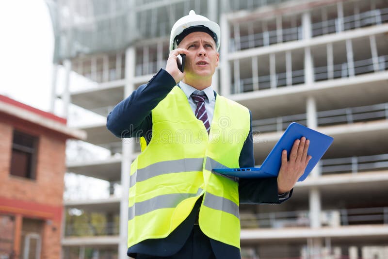Engineer with Laptop Talking on Phone Outdoors Stock Photo - Image of ...