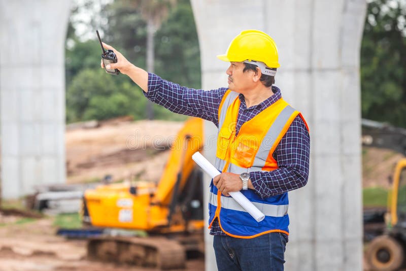 Engineer Man in Hardhat with Two-Way Radio at the Infrastructure ...