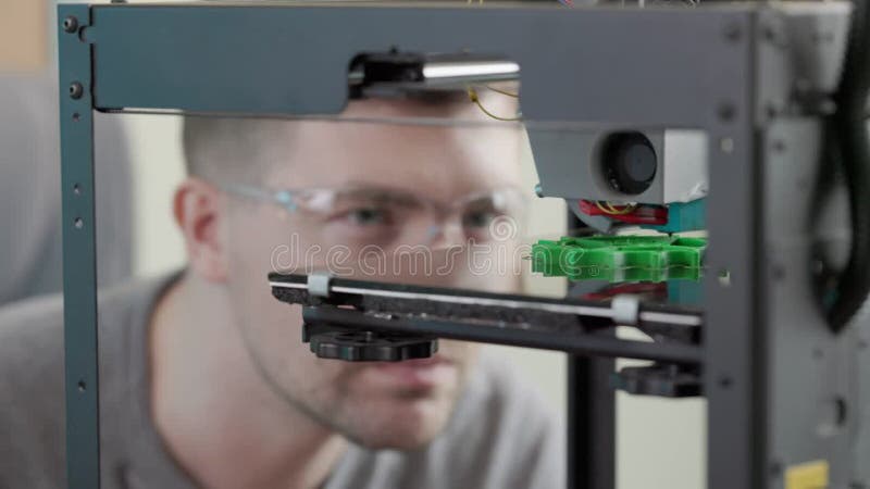 Engineer Man Wearing Glasses Watching the Process of Printing the Gear ...