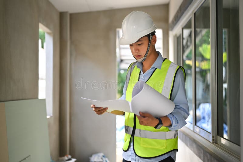 Engineer Man Working at Blueprints and Checking Building Construction ...