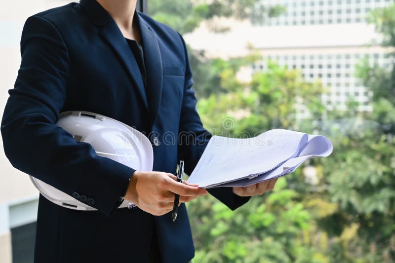 Engineer Manager Holding Helmet and Blueprints while Planning New ...
