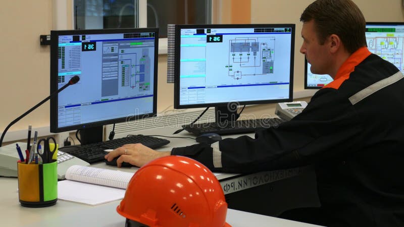 Engineer is Managing Complex Industrial System in Control Room while ...