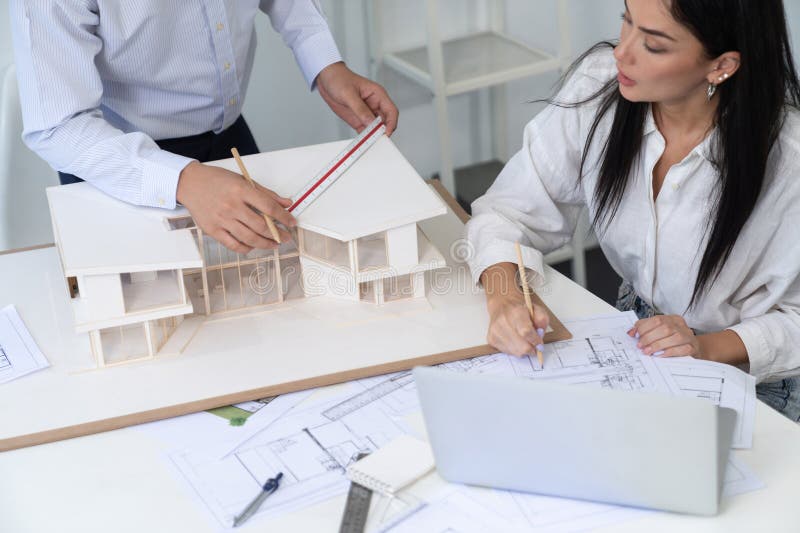 Engineer Measures Model while Skilled Designer Writes at Blueprint ...