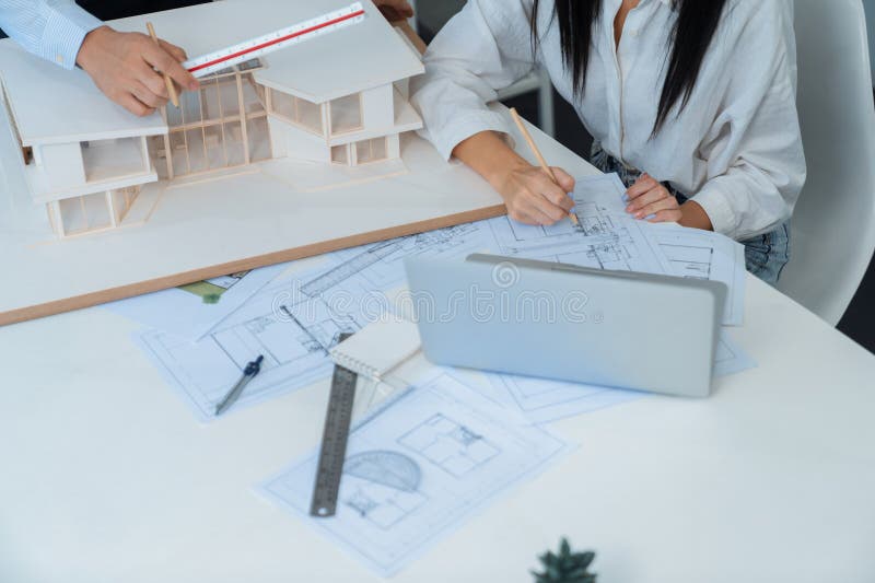 Engineer Measures Model while Skilled Designer Writes at Blueprint ...