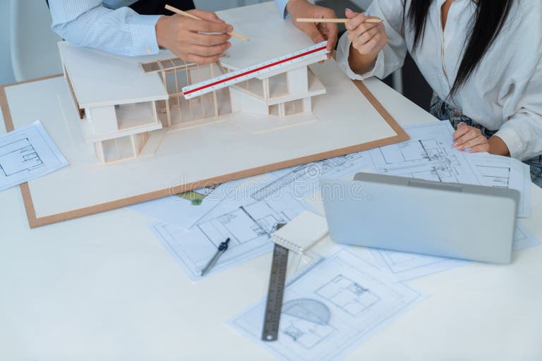 Engineer Measures Model while Skilled Designer Writes at Blueprint ...