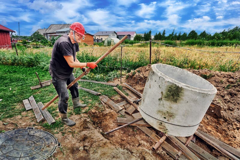 An Engineer Moves Concrete Ring Along Roller Bed during Installation of ...