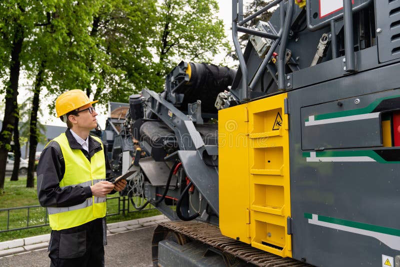 Engineer Next To Road Construction Machine. Stock Photo - Image of ...