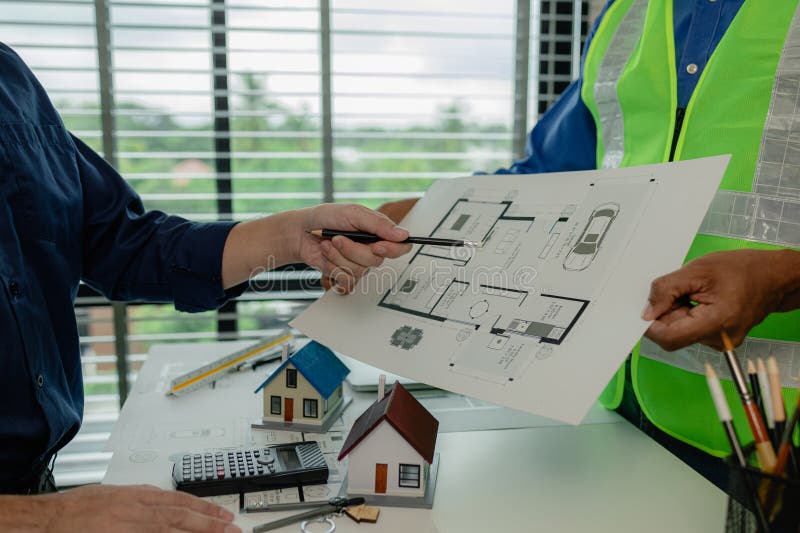 An Engineer is in the Office with His Assistant, they are Examining ...