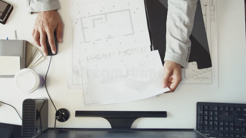 The Engineer Opens a Folder with Drawings and Works at the Table ...