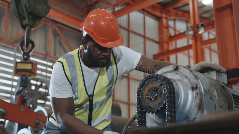 Engineer or Operator Wearing a Safety Suit Maintaining Machine in the ...
