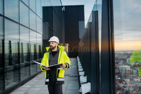 Engineer Overseeing City Construction Project with Blueprints in Hand ...