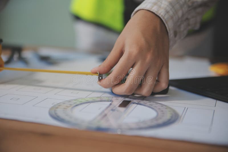 Engineer People Meeting Working and Pointing at a Blueprint in Office ...