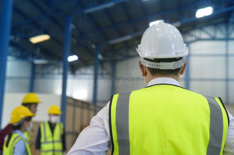 Engineer People are Putting a Protective Helmet on Head in Warehouse ...
