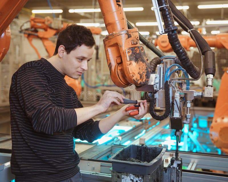 Engineer Performs Maintenance of Industrial Robot in a Factory Stock ... Engineer Performs Maintenance of Industrial Robot in a Factory Stock ...