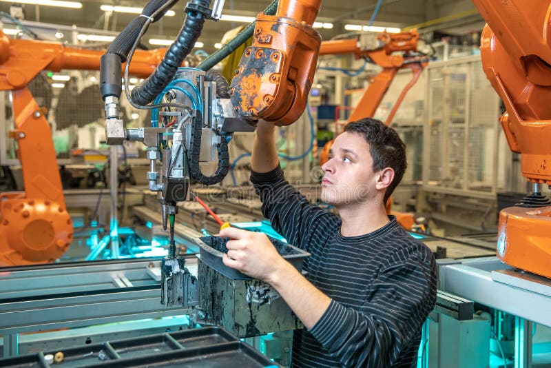 Engineer Performs Maintenance of Industrial Robot in a Factory Stock ...