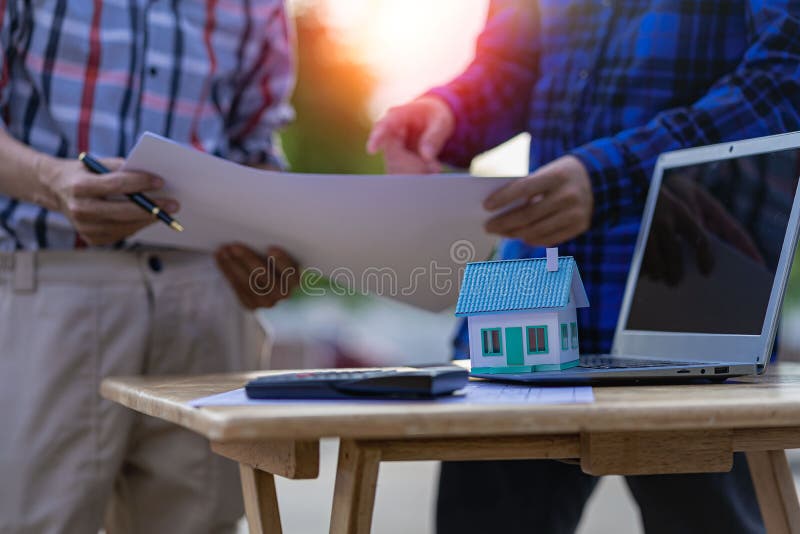 Engineer Pointing at Blueprint and Using Laptop To Draw Building Design ...