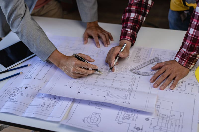 Engineer Pointing at Blueprint and Using Laptop To Draw Project Design ...