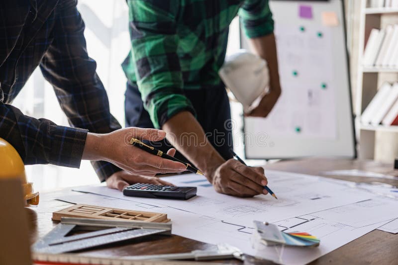 Engineer Pointing at Blueprint and Using Laptop To Draw Project Design ...