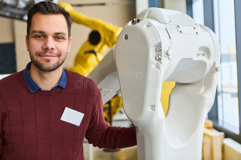 Engineer with Robot Arm in Industrial Setting, Focusing on Robotics and ...