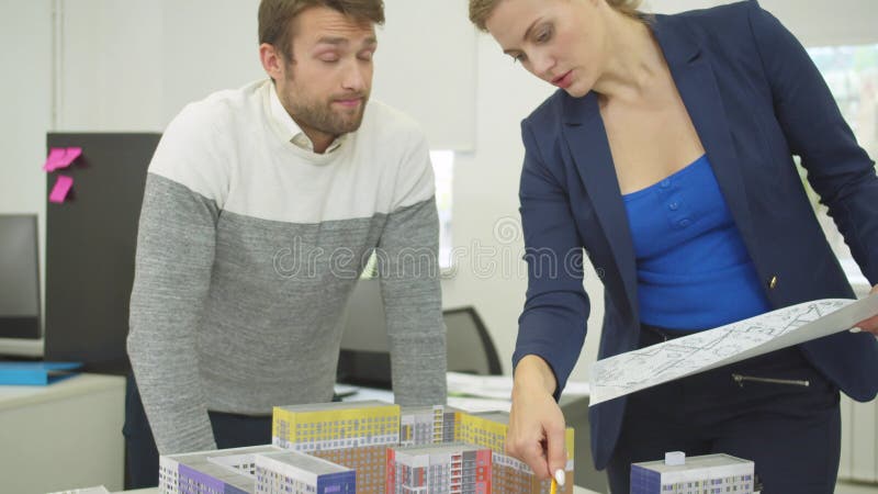 Engineer with Scheme in Hand Shows Models of Houses and Explain ...