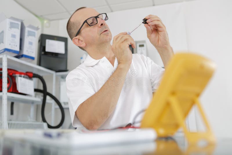 Engineer with Screwdriver Examining Circuit Board Stock Image - Image ...