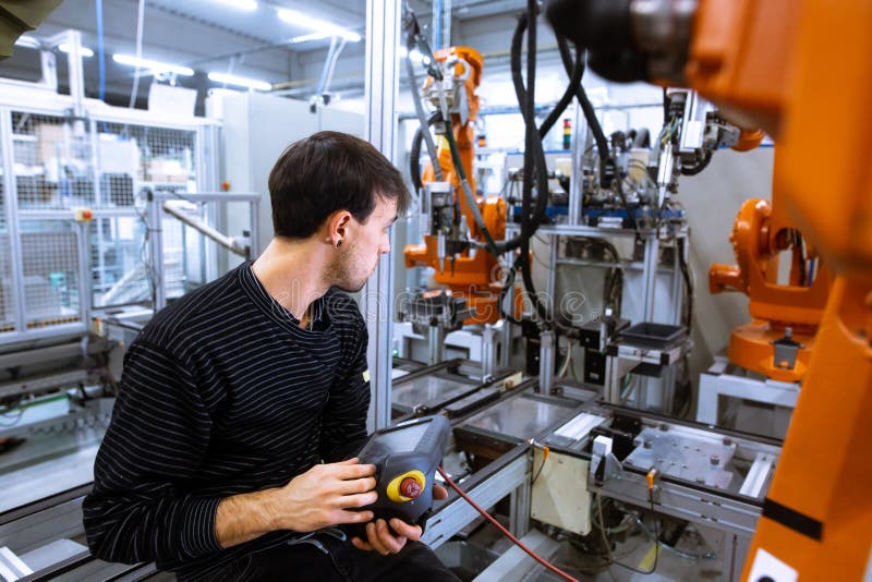 Engineer Setting Up Automatic Robot Arms in Smart Factory, Automotive ... Engineer Setting Up Automatic Robot Arms in Smart Factory, Automotive ...