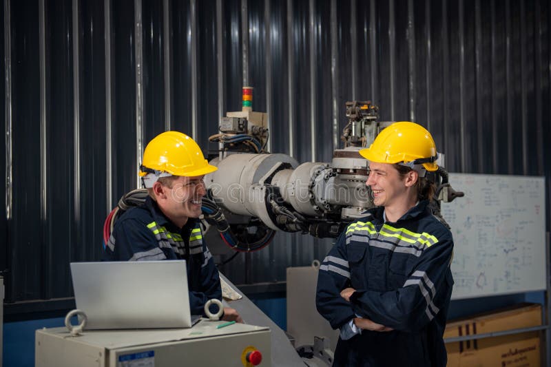 Engineer Standing by Robotic Arm and Operating Machine in Industry ...