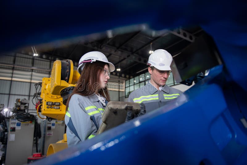 Engineer Standing by Robotic Arm and Operating Machine in Industry ...