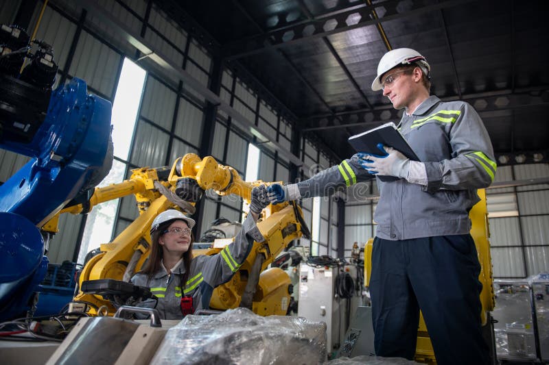 Engineer Standing by Robotic Arm and Operating Machine in Industry ...