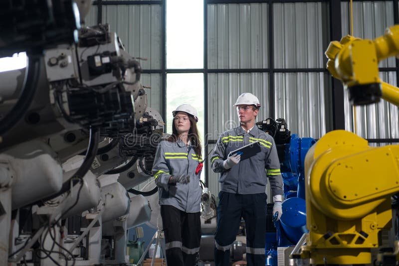 Engineer Standing by Robotic Arm and Operating Machine in Industry ...