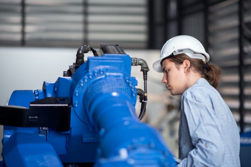 Engineer Standing by Robotic Arm and Operating Machine in Industry ...
