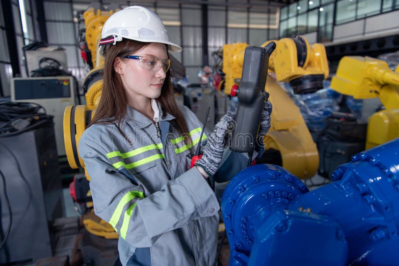 Engineer Standing by Robotic Arm and Operating Machine in Industry ...