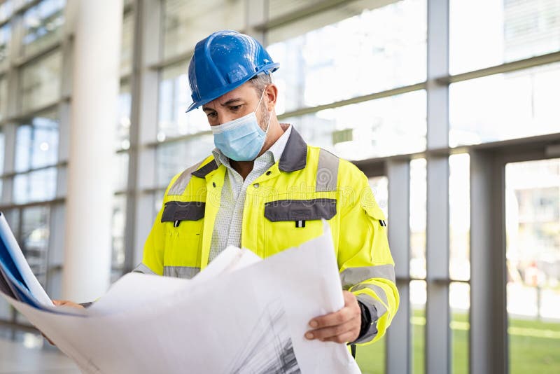 Engineer Studying Plan at Construction Site with Protective Face Mask ...