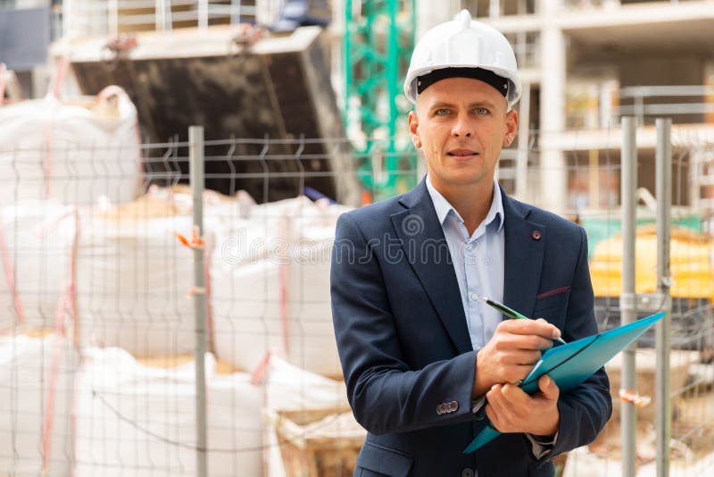 Engineer in Suit Standing in Construction Area with Folder in Hands ...