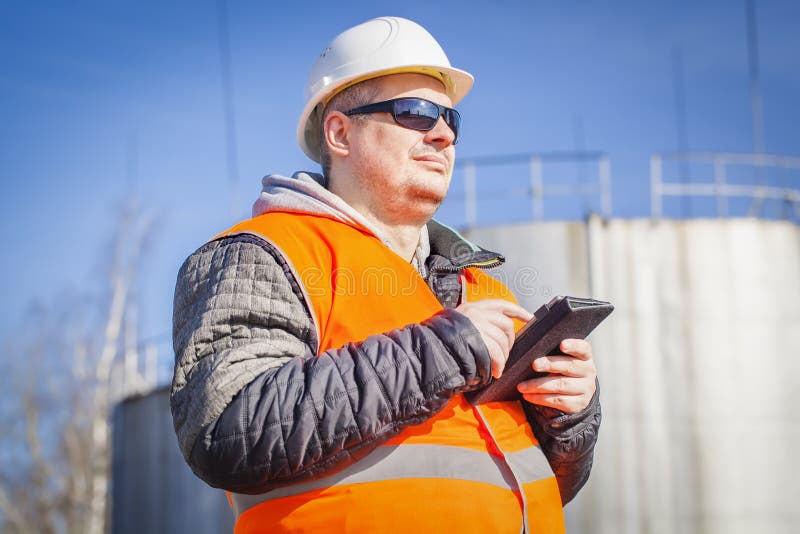 Engineer with Tablet PC with Oil Tank in the Background Stock Image ...