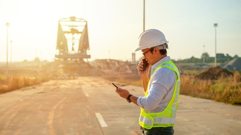 Engineer Talking on Walkie-talkie and Using Smart Phone for Working at ...