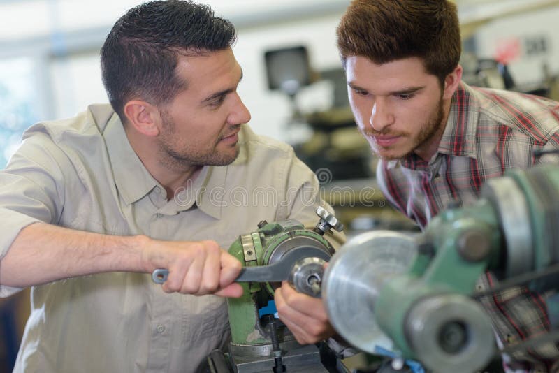 Engineer Teaching Apprentices Using Metal Processing Machines Stock ...