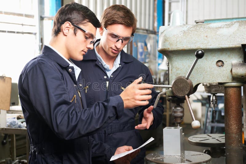 Engineer and Trainee Using Equipment in Factory Stock Photo - Image of ...