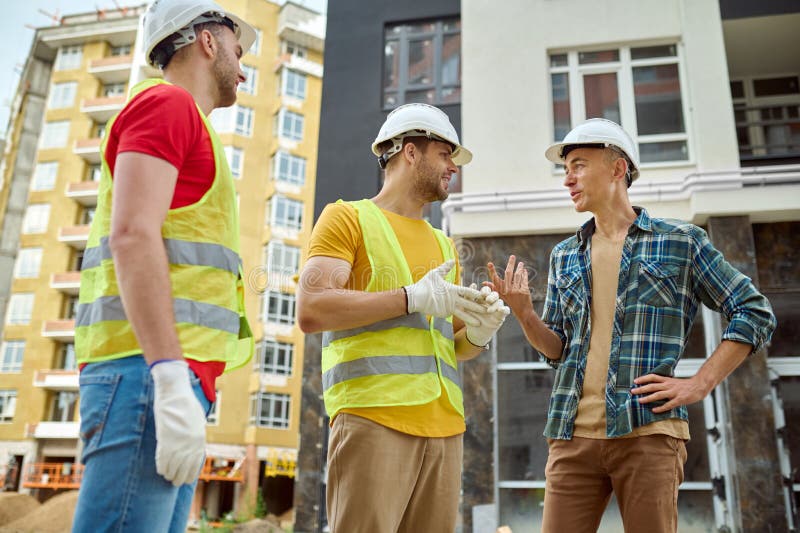 Engineer and Two Workers Communicating at Construction Site Stock Image ...