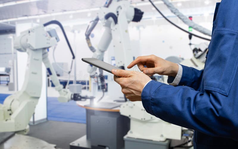 Engineer Uses A Digital Tablet To Control Robots In A Smart Factory
