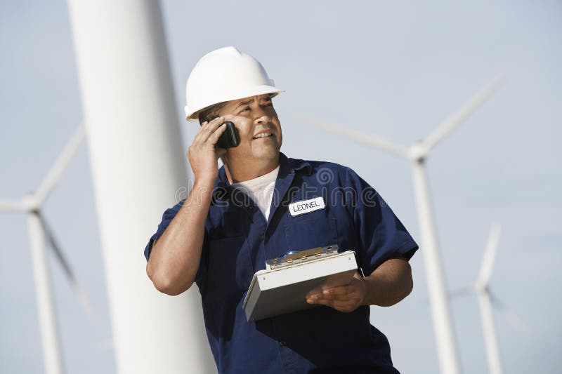 Engineer Using Cell Phone at Wind Farm Stock Photo - Image of middle ...