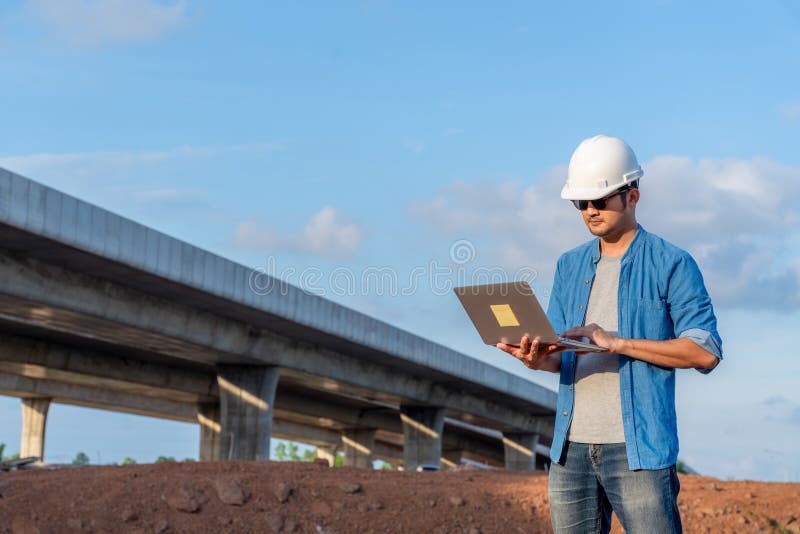 An Engineer is Using Laptop at Road Construction Site. Civil Engineer ...