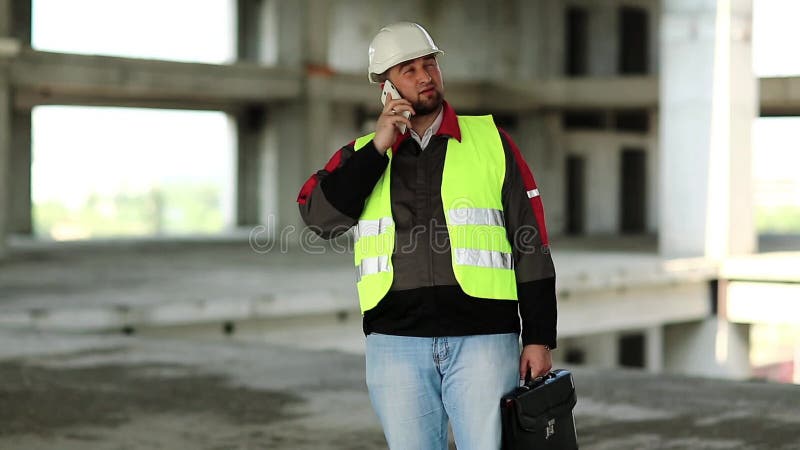 Workman Talks on Cell Phone at Construction Site Stock Video - Video of ...